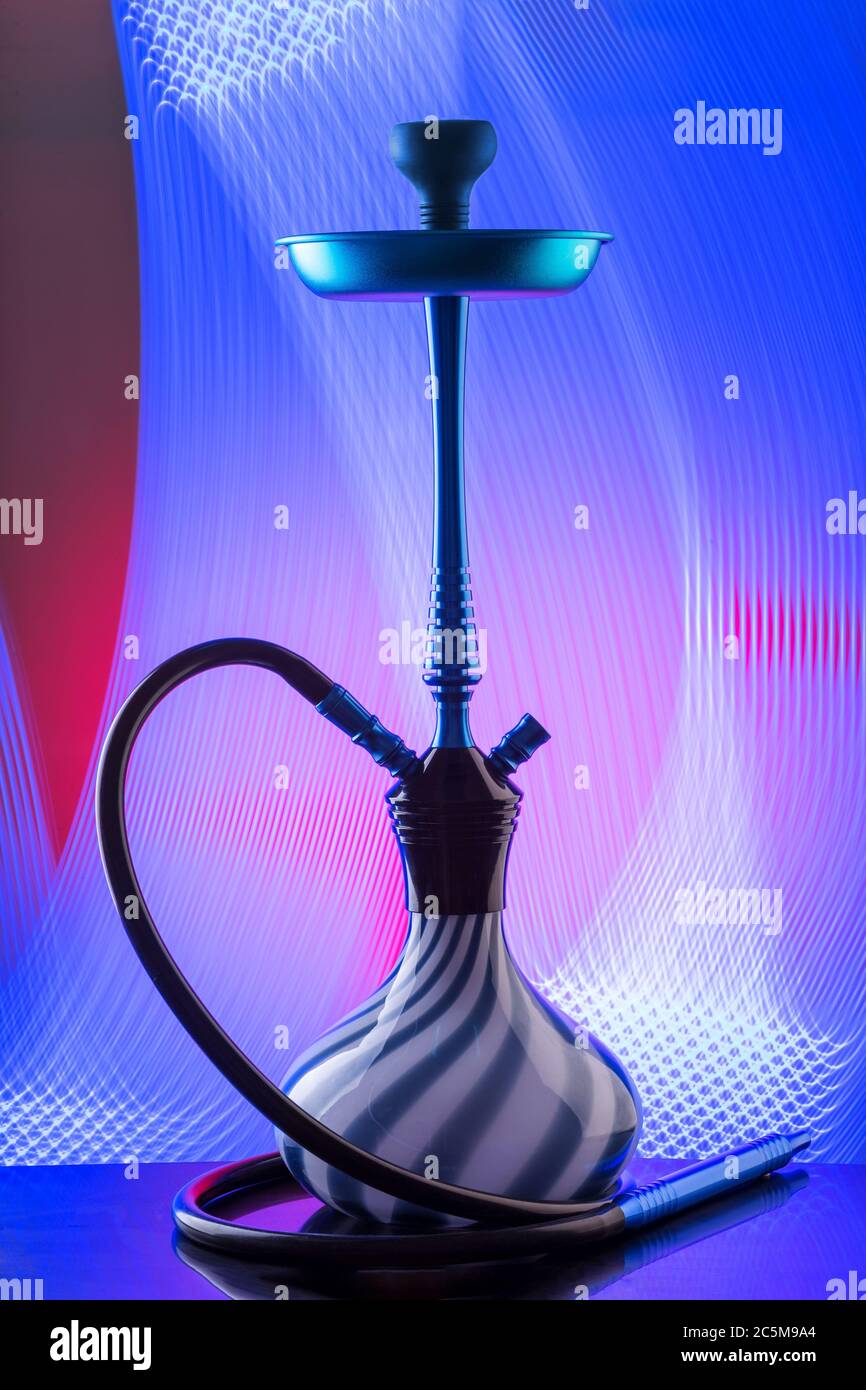 Blue hookah with black rubber tube and blue and white flask on ...