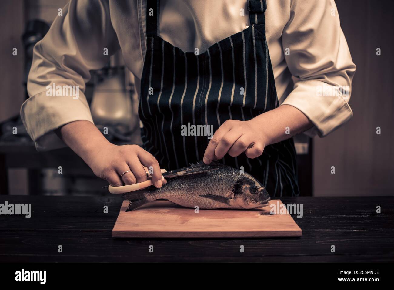 Chef cutting the fish on a board Stock Photo - Alamy