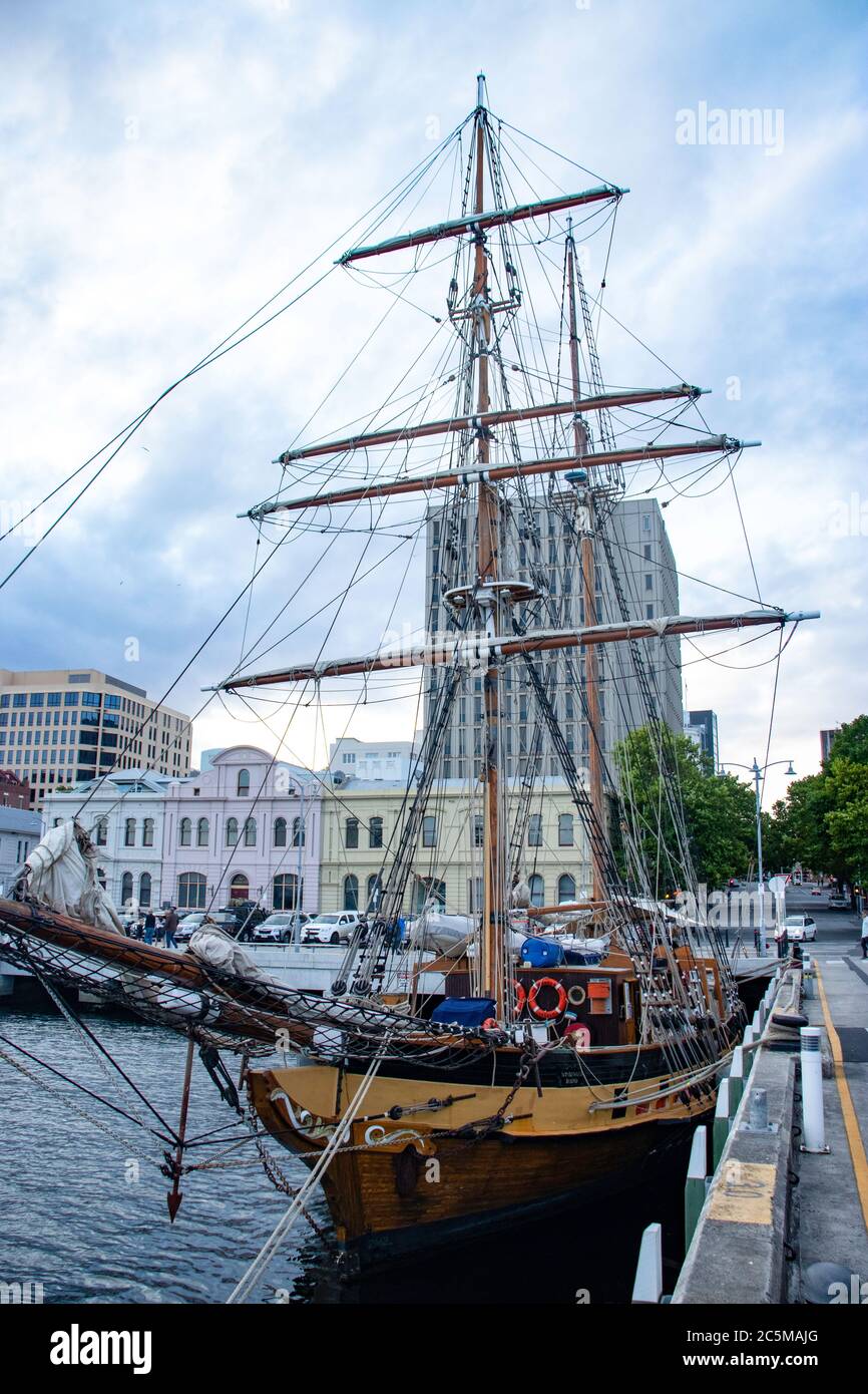Pirate ship docked at a town pier with buildings in the background ...