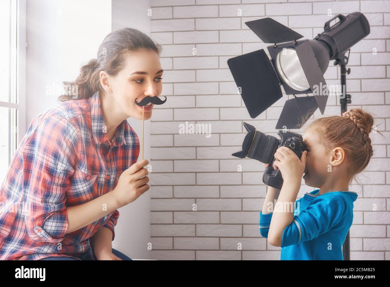 Photographer in motion. Young woman photographer and child girl having ...