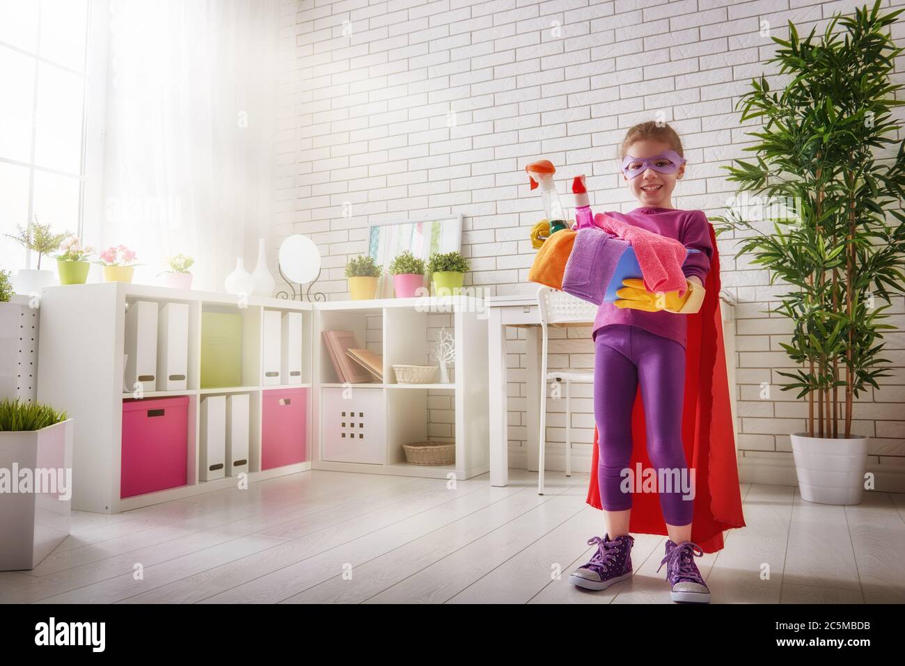 Charming little helper. Cute little child girl makes cleaning the house ...