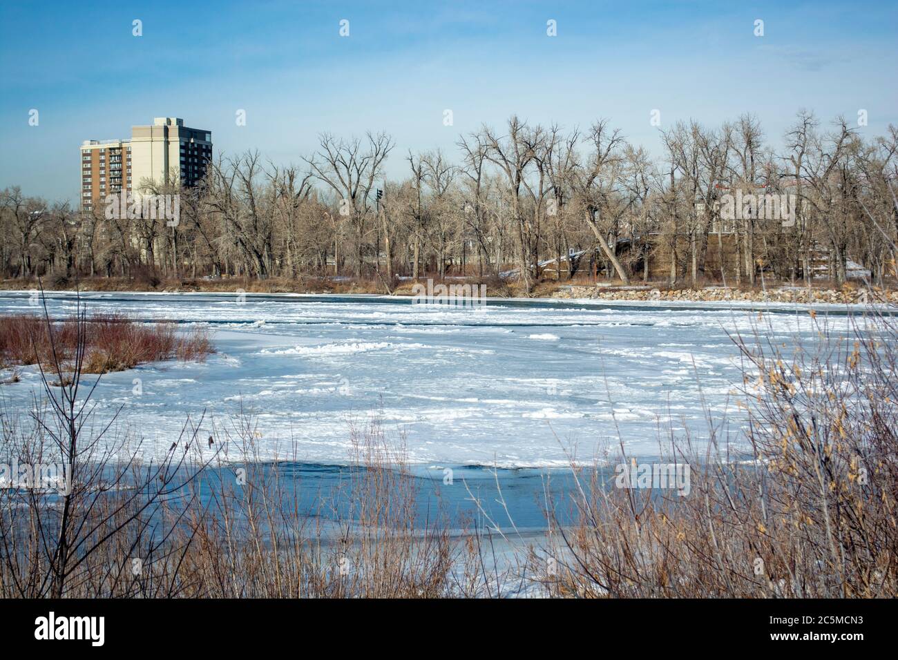 Frozen River Iced Over With Trees Lining Edges Stock Photo - Alamy