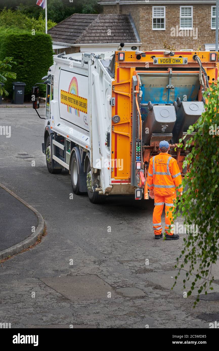 A recycling collector, in high visibility orange clothing, inspects ...