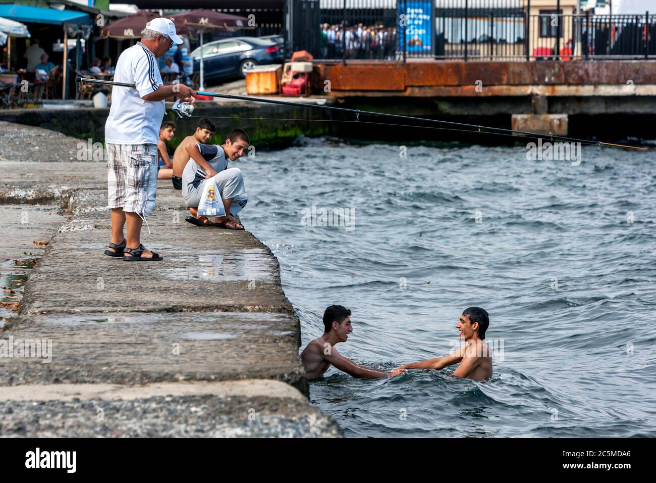 Men play adjacent to a dock in the Bosphorus at Findikli in Istanbul in ...