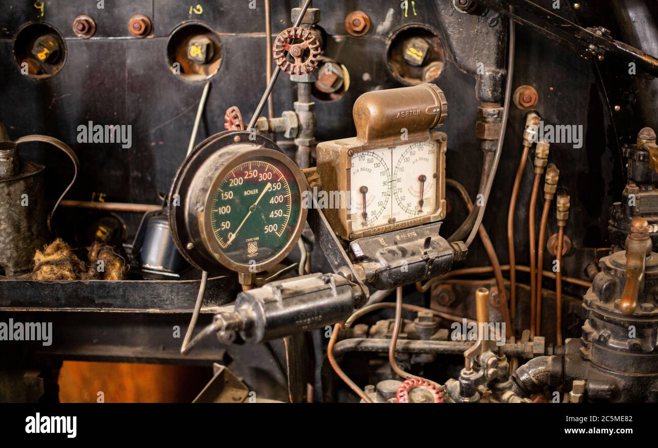 Rusty old valves, gauges and metal parts on an antique steam locomotive ...