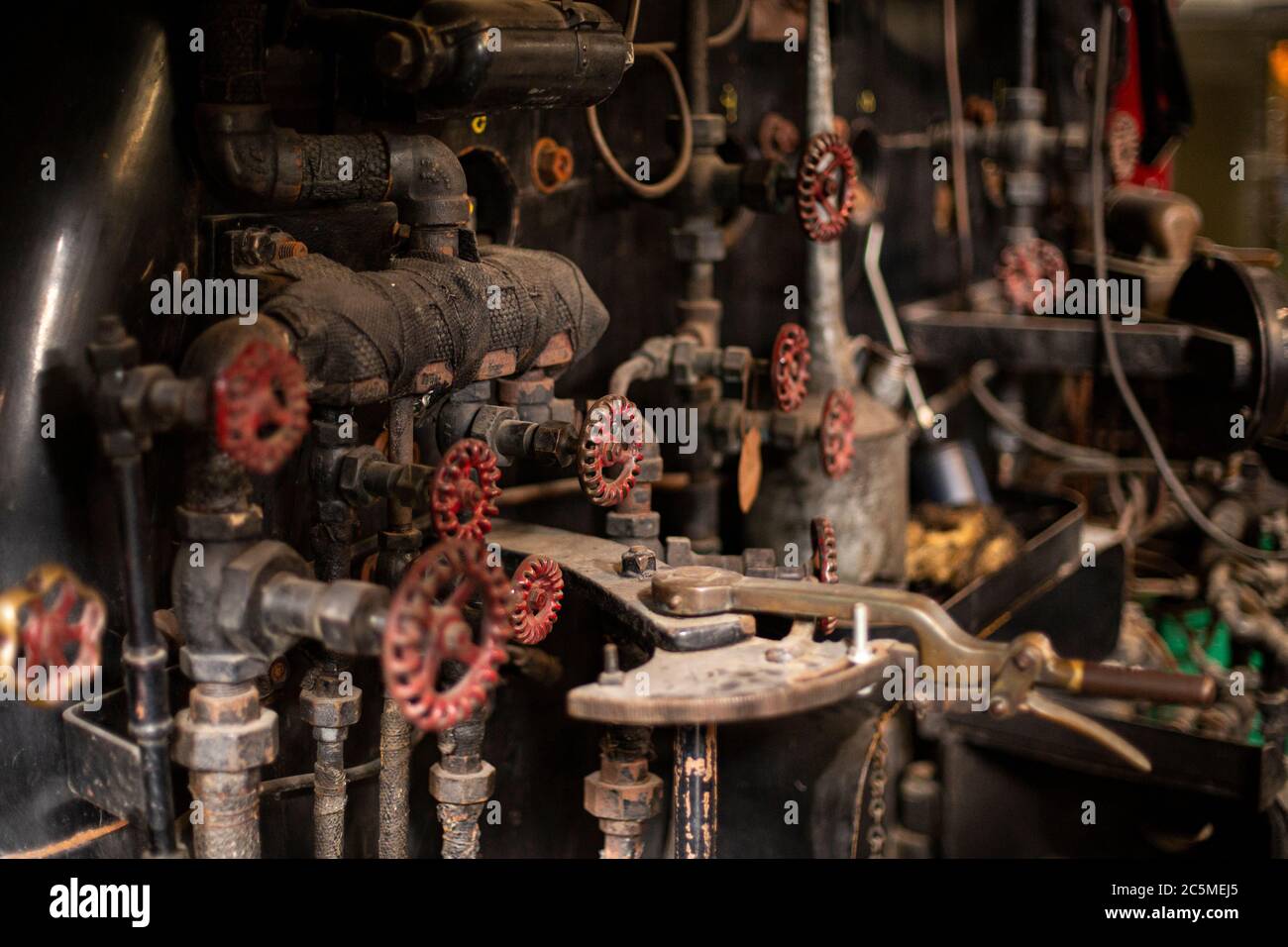 Rusty old valves, gauges and metal parts on an antique steam locomotive ...