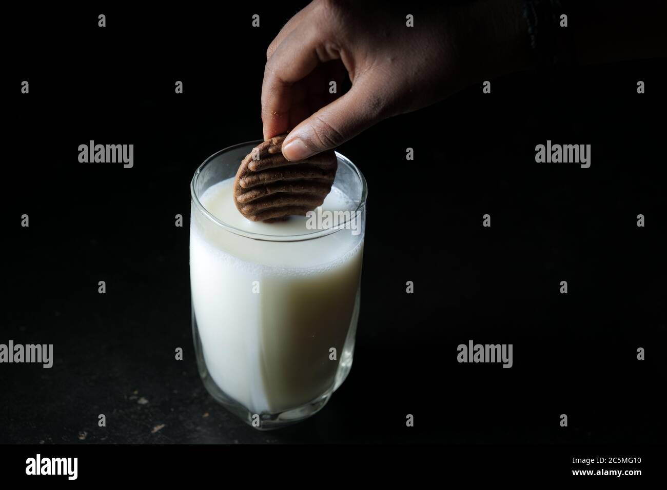 Biscuit soak in glass of milk Stock Photo - Alamy