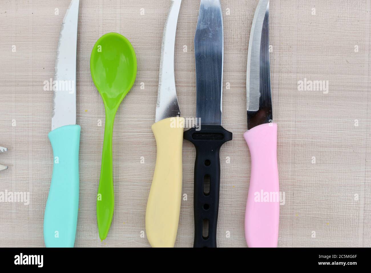 Colorful knives close display on a white texture surface. Cutter and ...