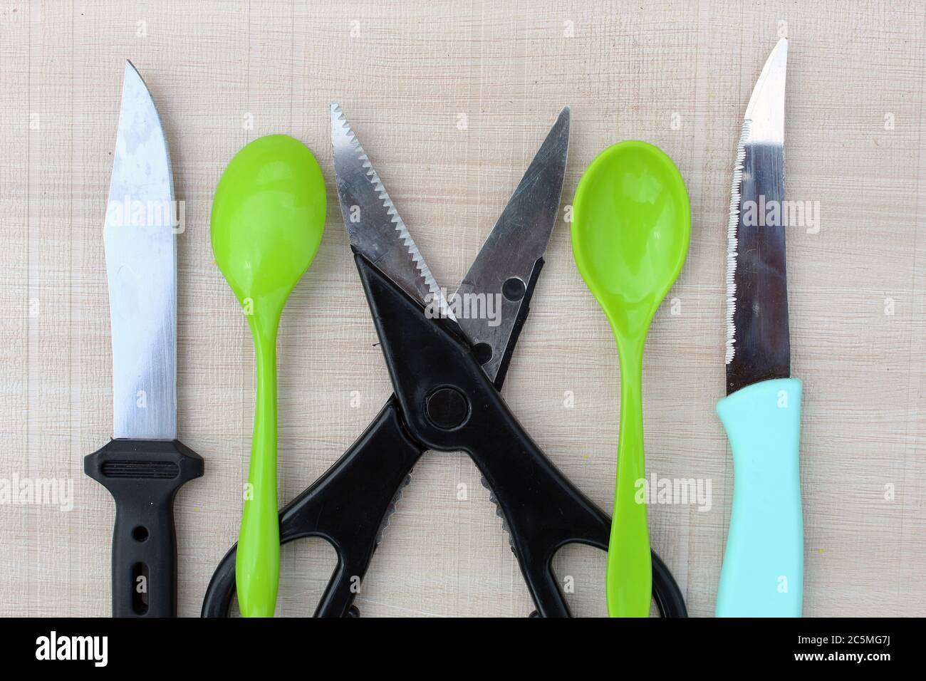 Colorful knives and scissor close display on a white texture surface ...