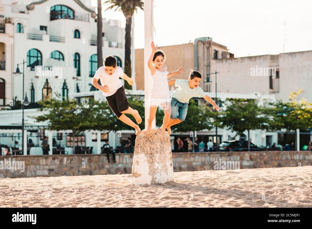 Three kids jumping on the beach at summer Stock Photo - Alamy