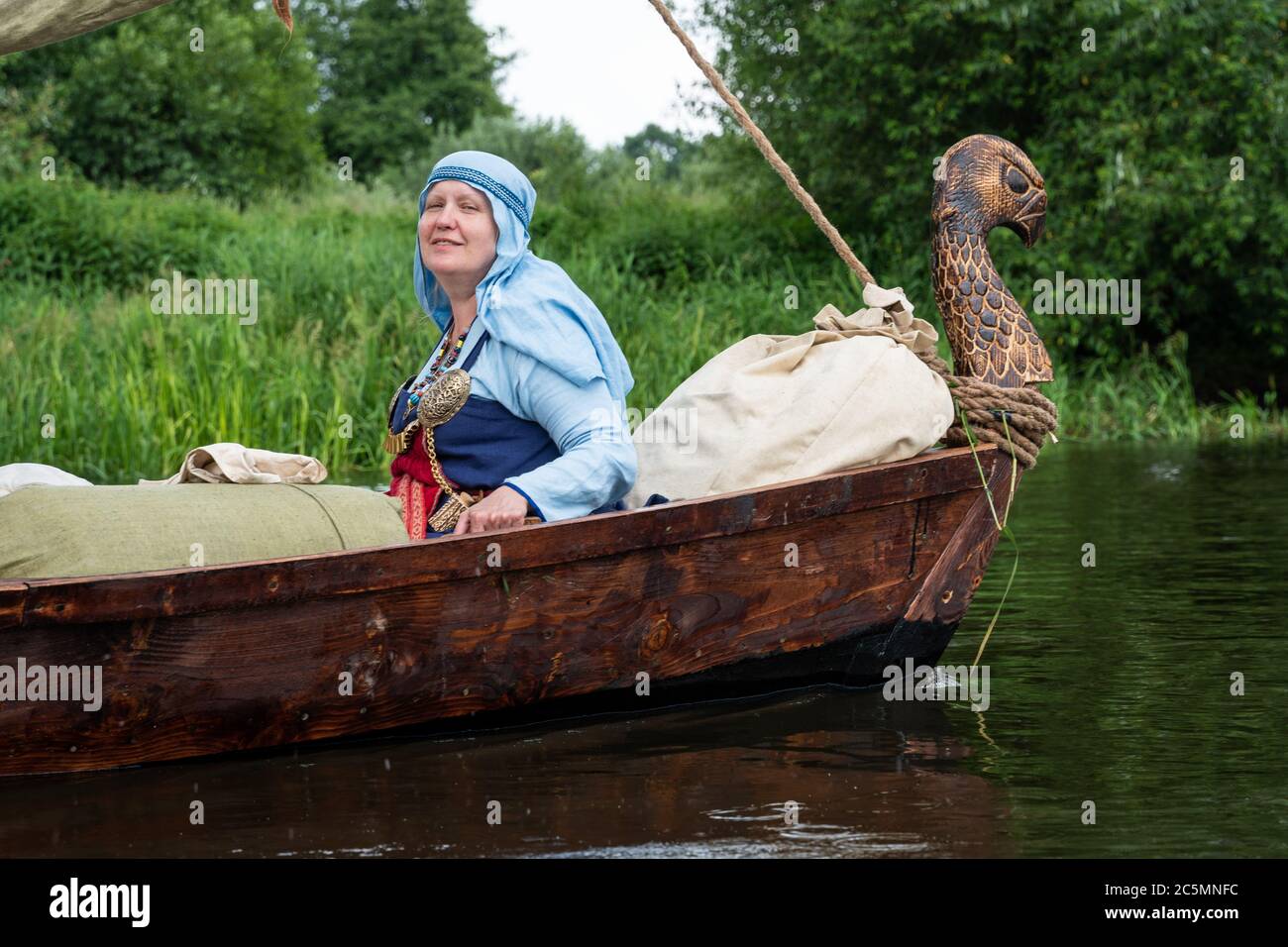 A woman in Viking clothing (9-11th century) sits on the bow of an ...
