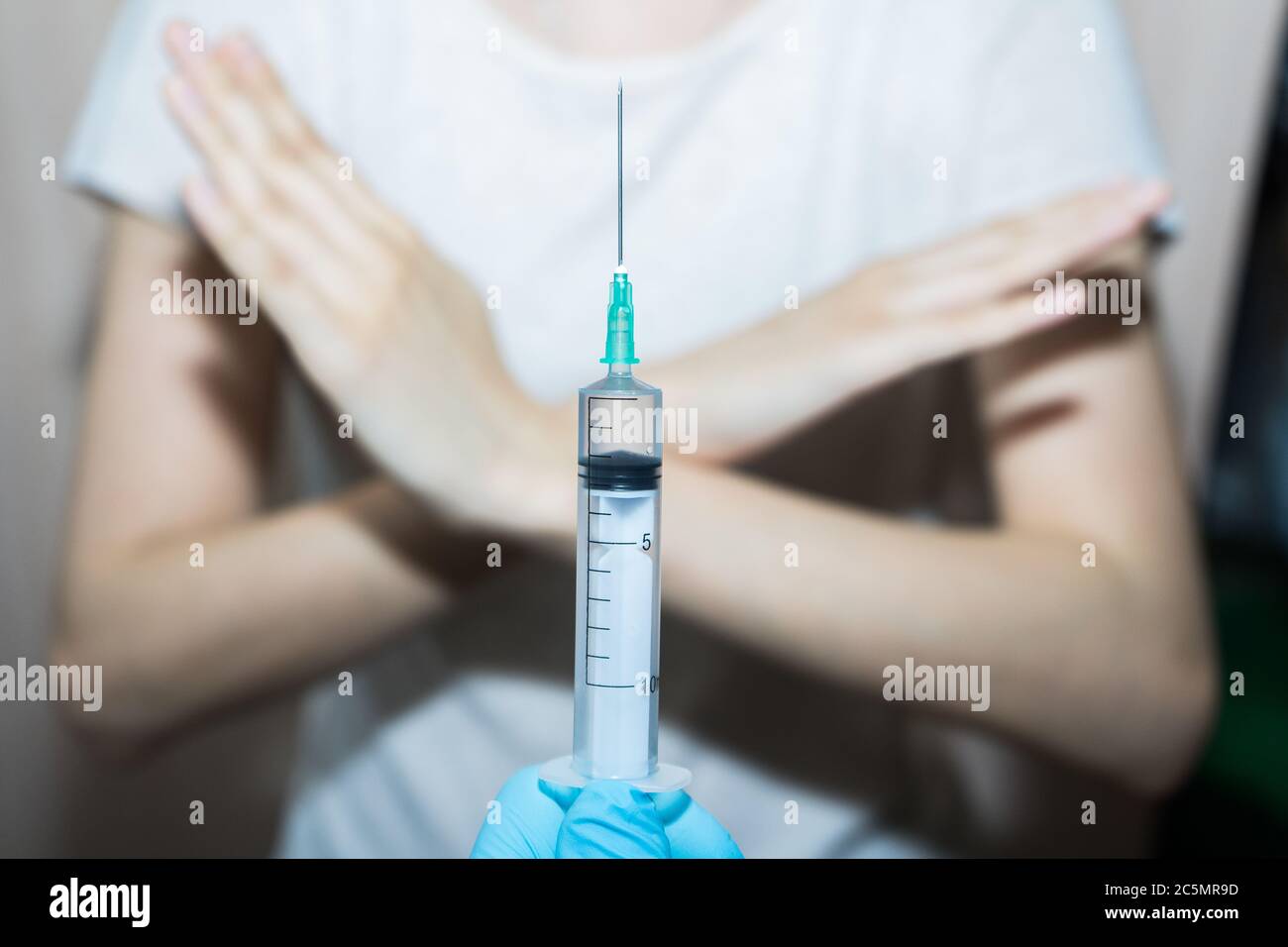 Stop vaccinations. A syringe in the doctor hand and a patient says no ...