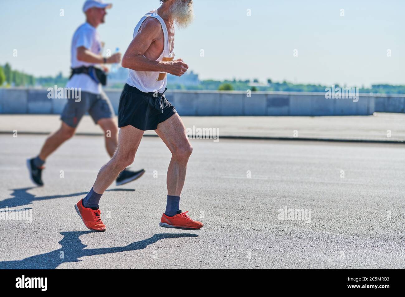 Running old man. Old man jogging in sportswear on city road. Healthy ...