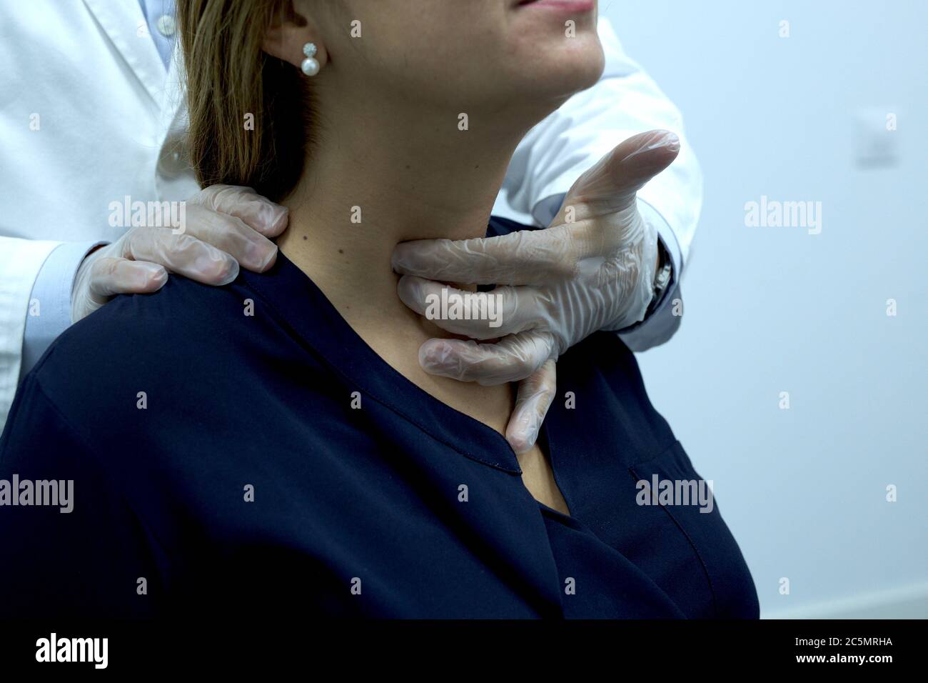 endocrine physician performing a physical exam on the neck of a patient ...