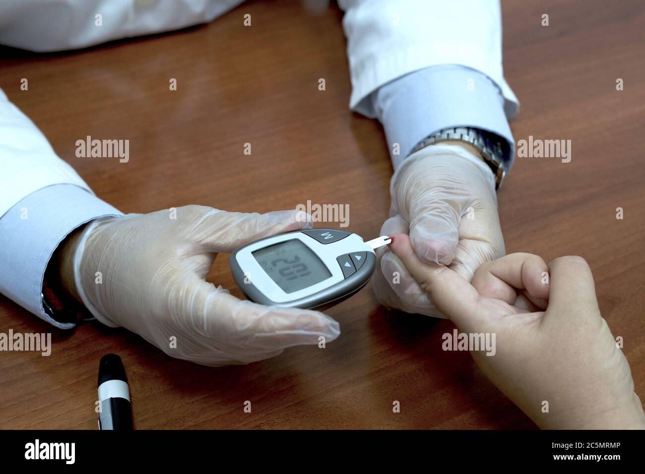 doctor doing a finger blood test to check the patient's blood sugar ...