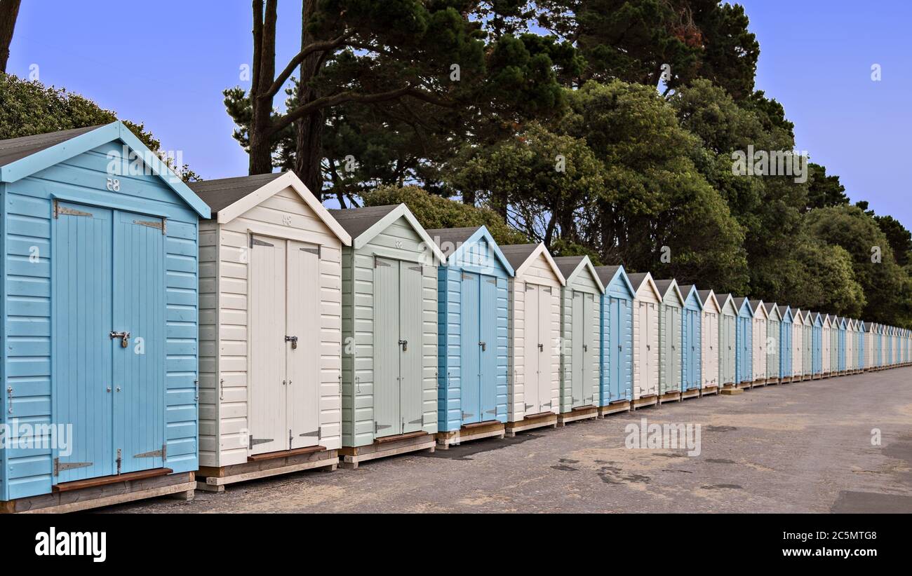 Beach huts on Avon Beach near Mudeford Christchurch with a blue sky and ...