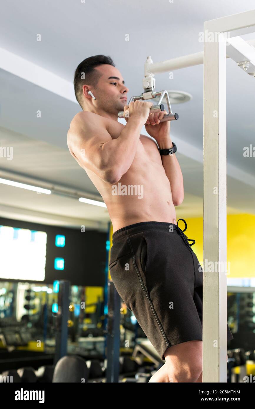 Muscular young man performing back exercises. inside the gym Stock ...