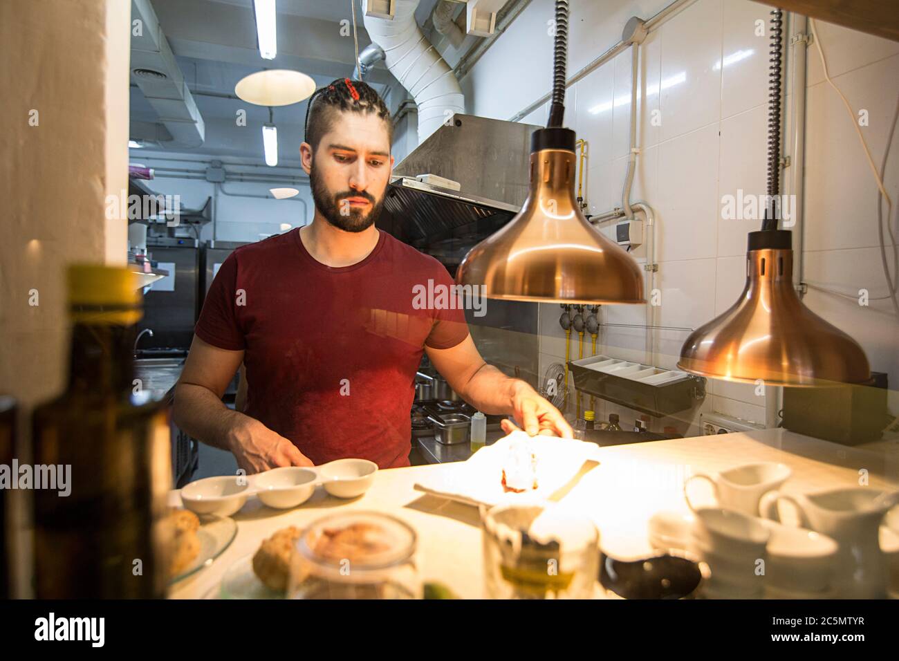 Chef working inside the kitchen, finishing a dish for the service of a ...
