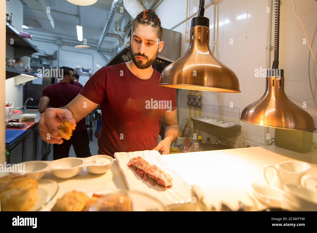 Chef working inside the kitchen, finishing a dish for the service of a ...