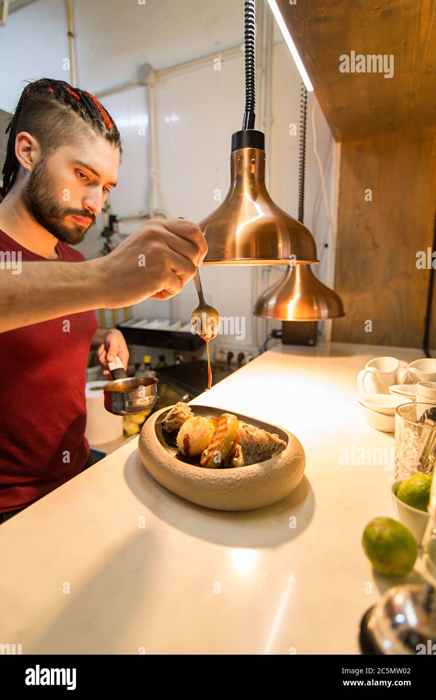 Chef finishing a plate inside gourmet restaurant kitchen Stock Photo ...