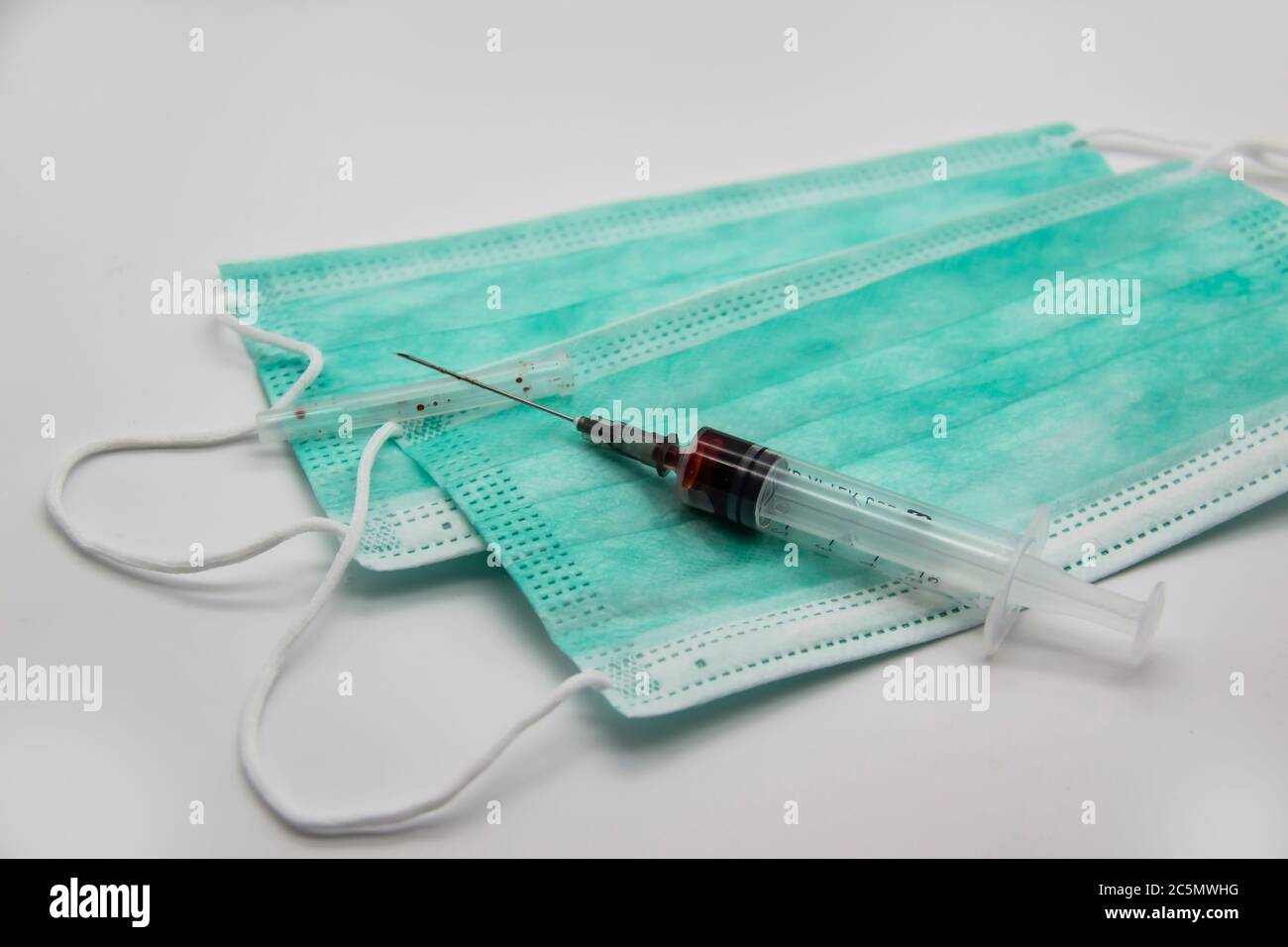 Medical masks and syringe with blood on a white background. Medical ...