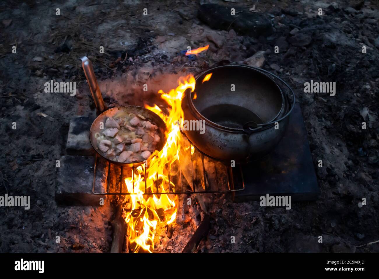 Field kitchen in the forest. Water boils and cooking food. Boiling pot ...
