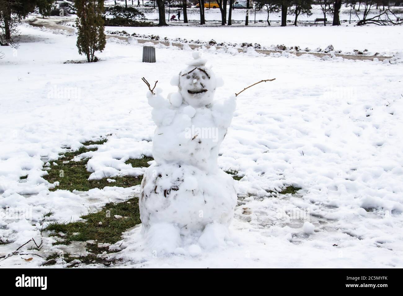 Dirty snowman in the park in the cold snowy day. A terrible snowman ...
