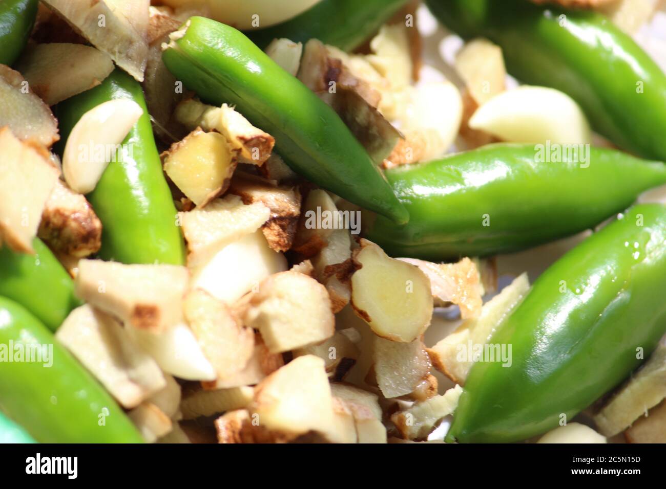 Green fresh chilli display with raw ginger cut pieces together with ...