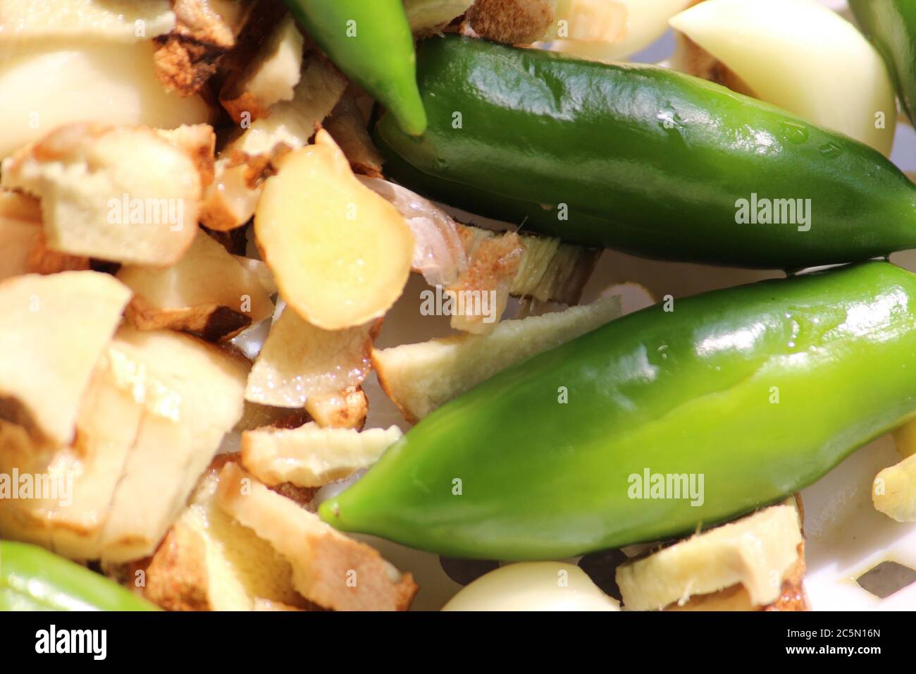 Green fresh chilli display with raw ginger cut pieces together with ...
