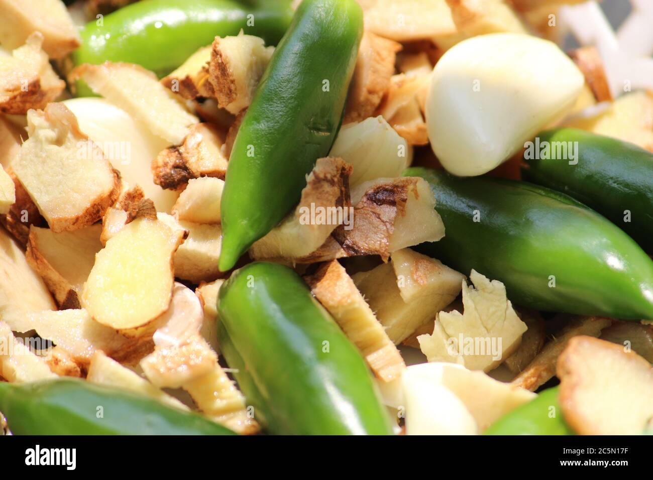 Green fresh chilli display with raw ginger cut pieces together with ...