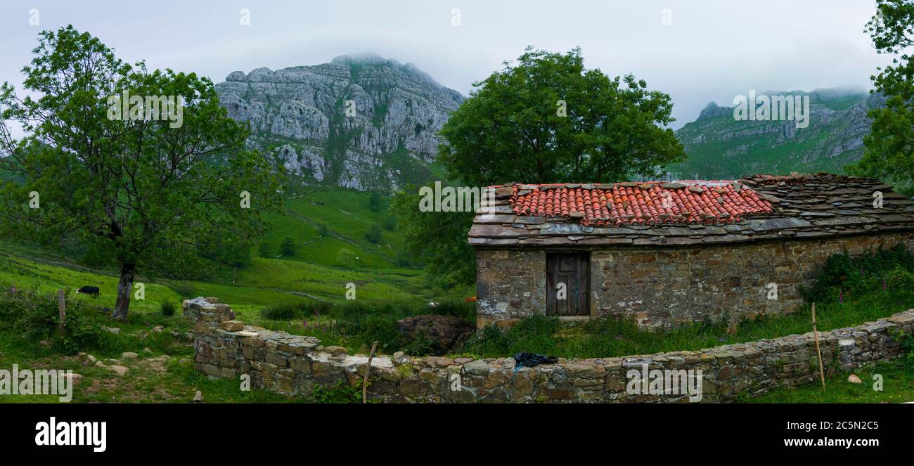 Spring landscape of mountains, meadows of mowing and cabins pasiegas in ...