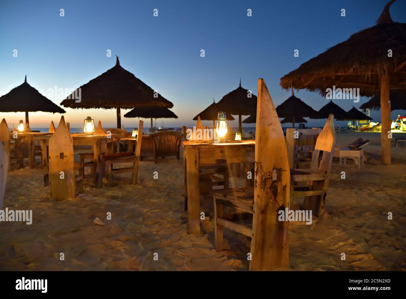 Romantic night on Indian ocean shore. Beach cafe and lighting lanterns ...