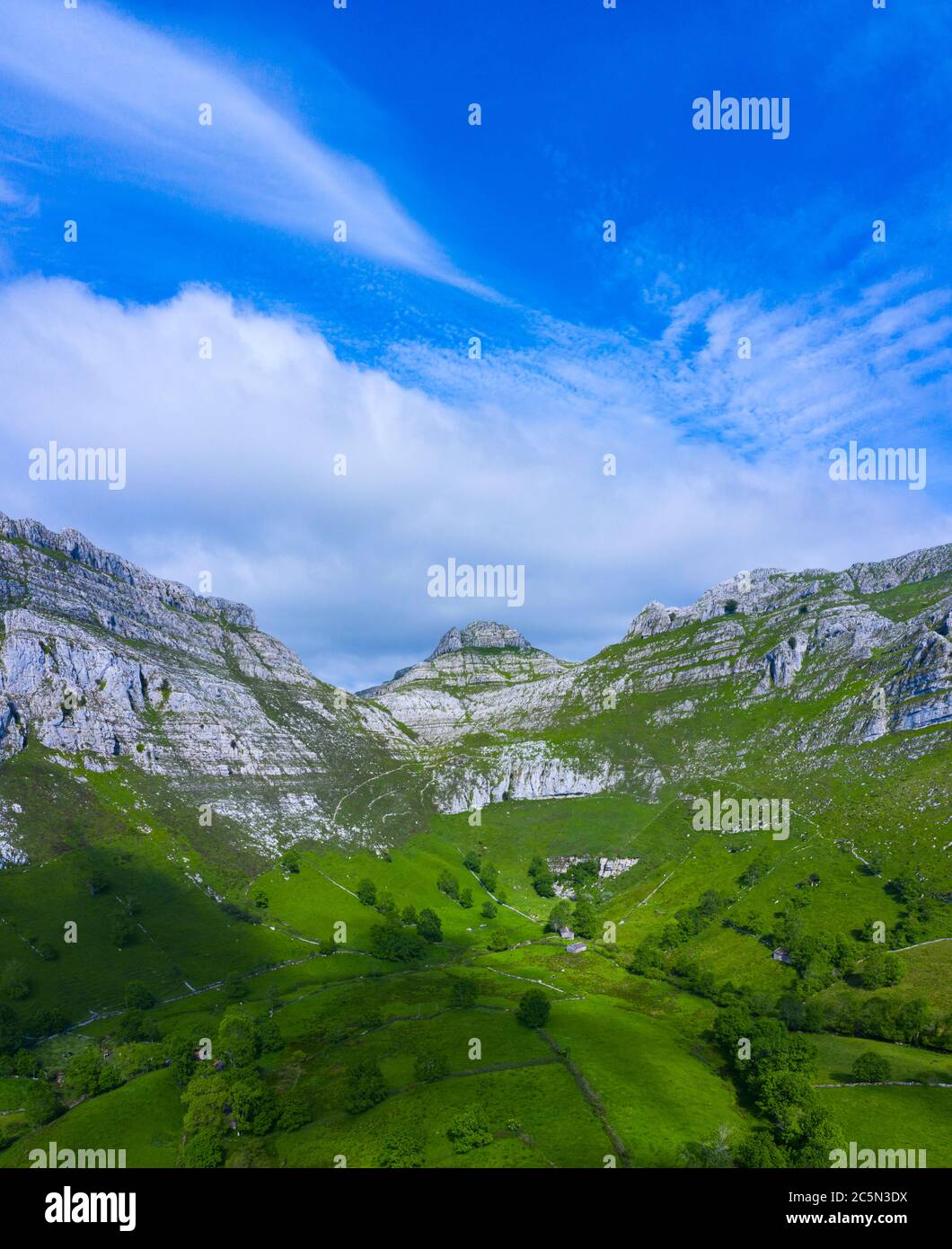 Spring landscape of mountains, meadows of mowing and cabins pasiegas in ...