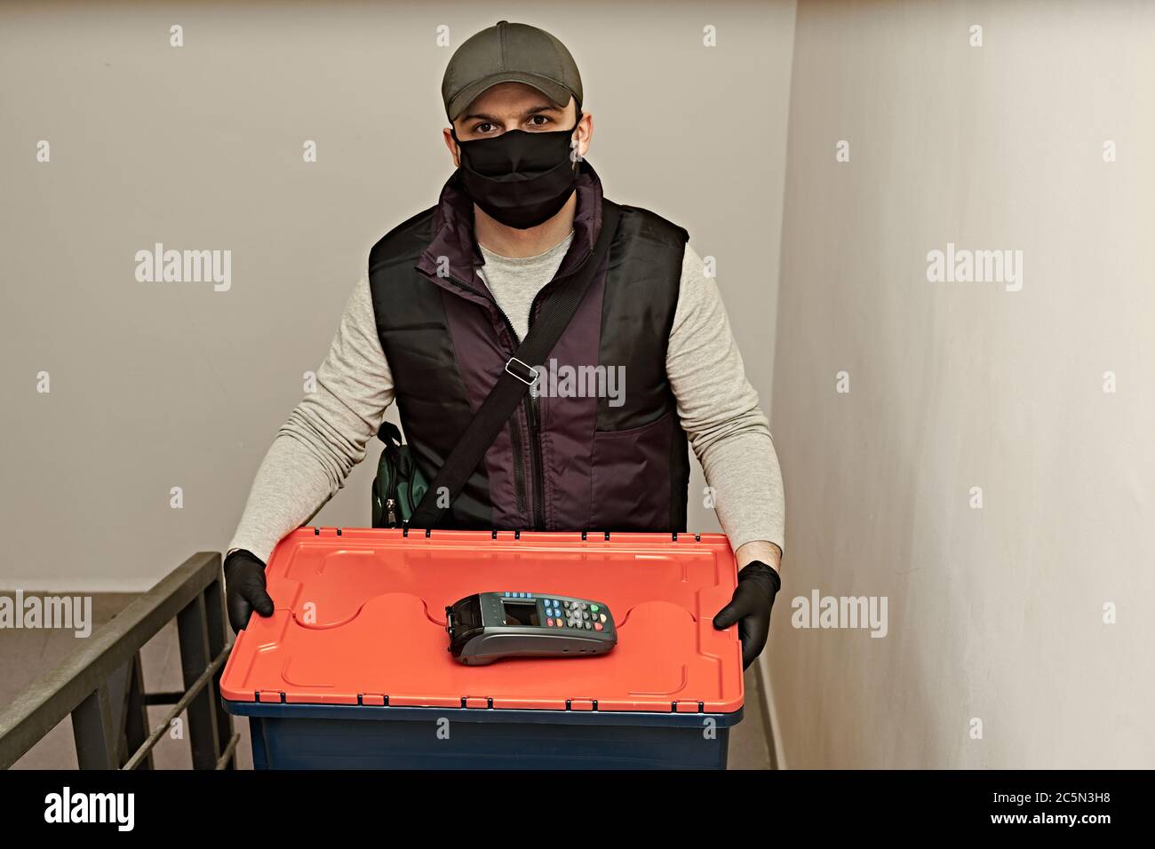 A courier in a protective mask delivers food. Delivery under quarantine ...