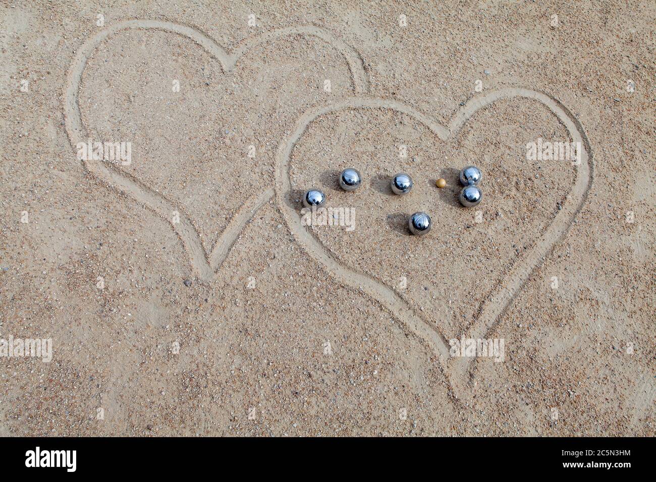 Bocce balls in sand with signed hearts Stock Photo - Alamy
