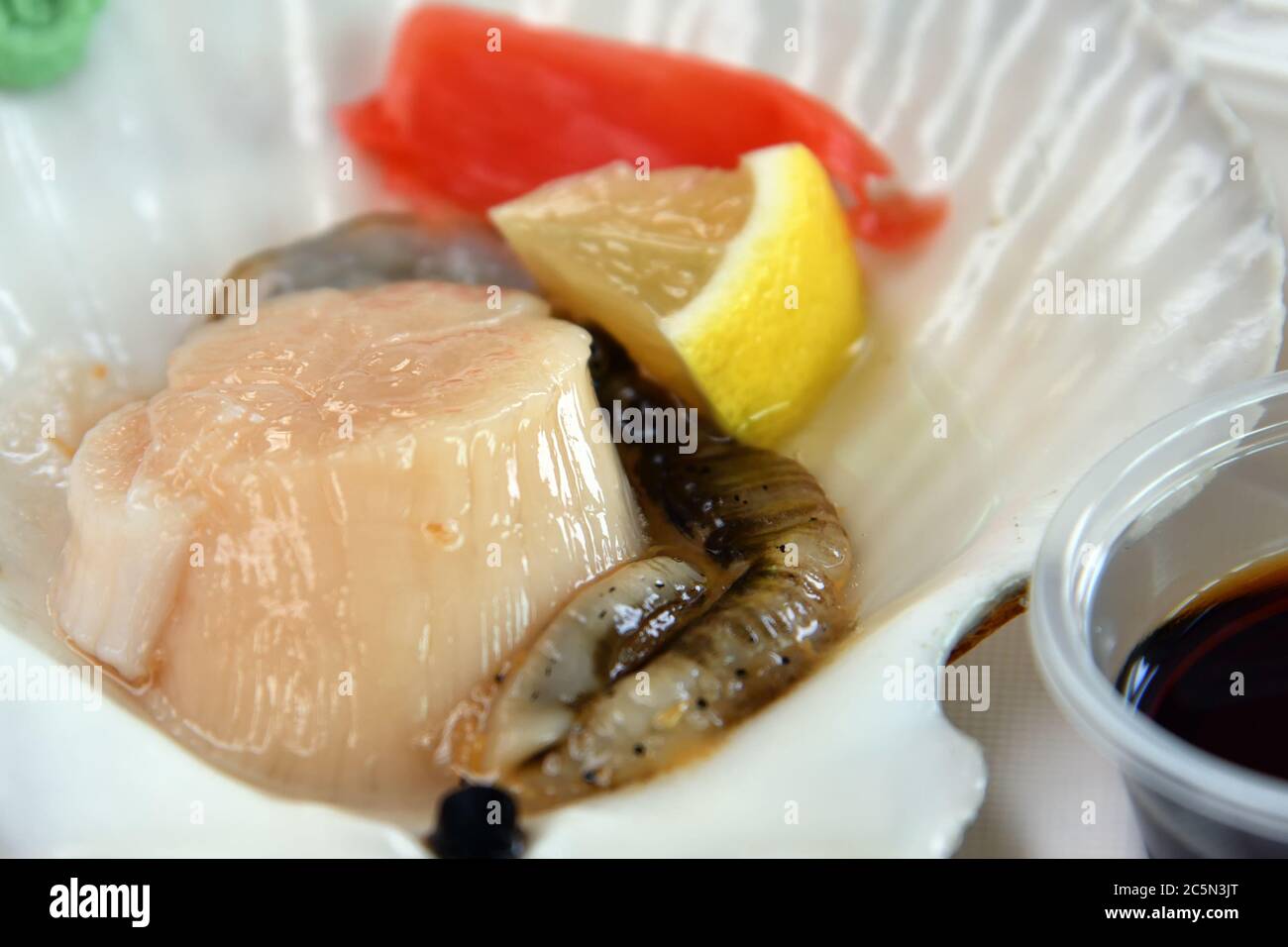 Raw scallop shell with lemon, wasabi and soy sauce. Pacific seafood ...