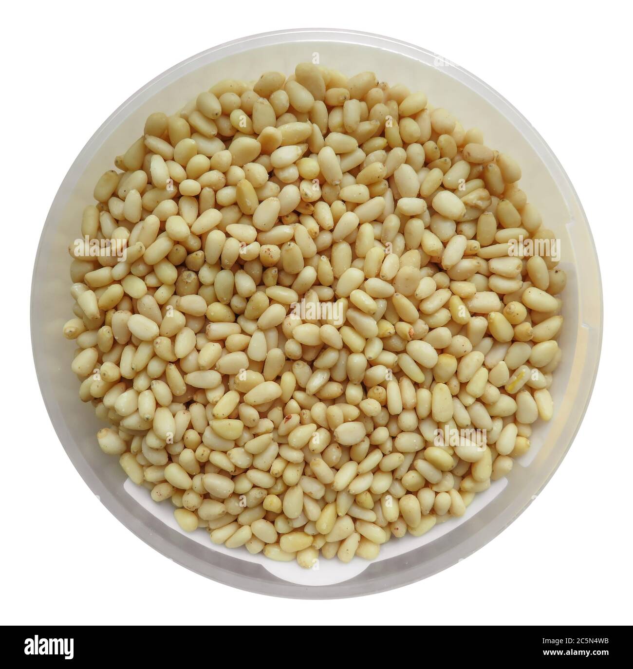 Whole white peeled pine nuts in the plastic container isolated on white ...