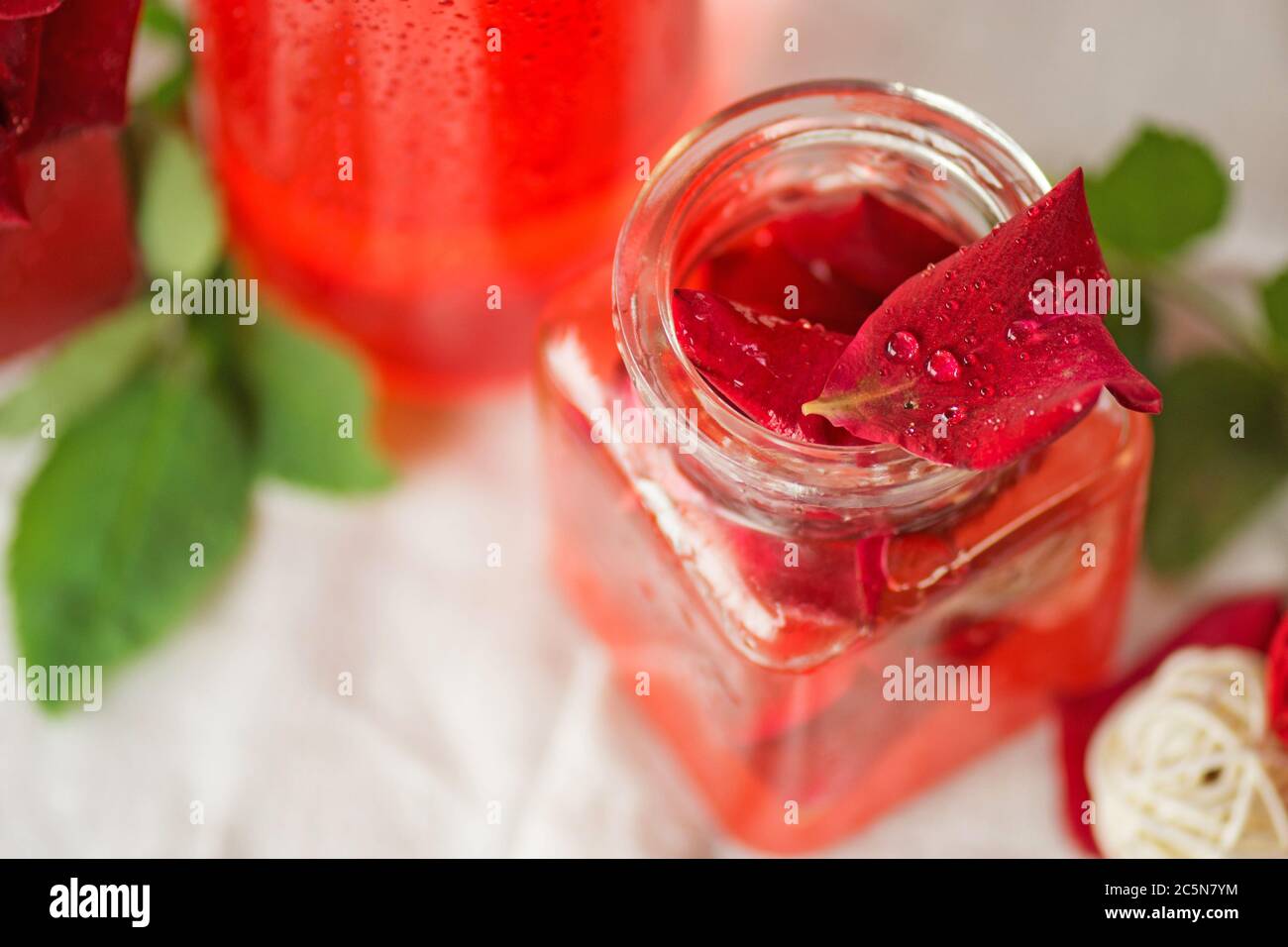 Pink rose flower and glass of rose water. Fresh organic rose water ...