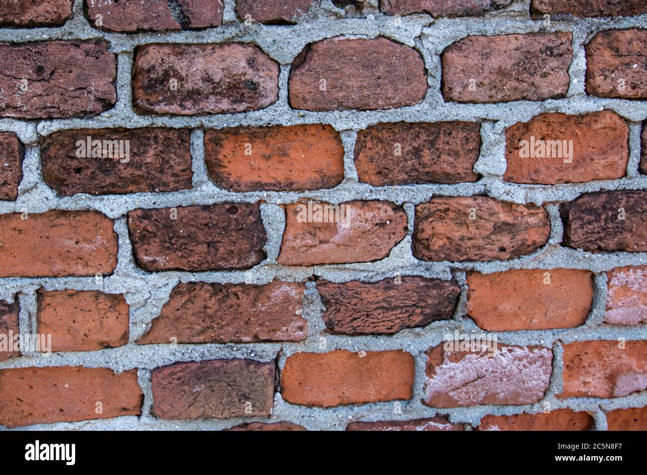 background made with old and handmade reddish bricks of slightly ...