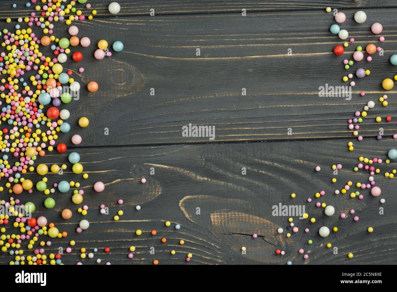 Colorful foam ball texture. Colorful polystyrene foam on a black wooden ...