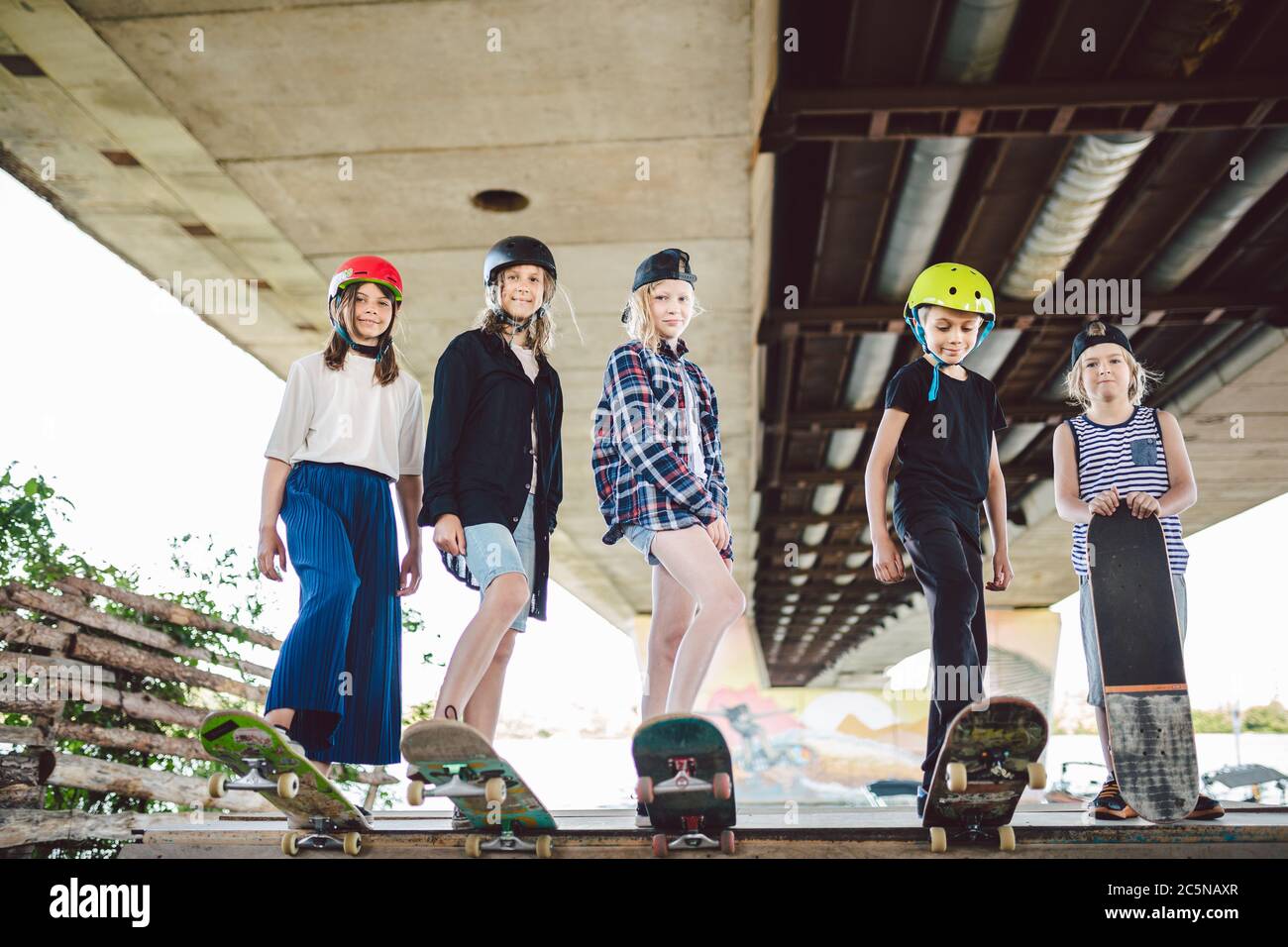 Group of friends children at skate ramp. Portrait of confident early ...