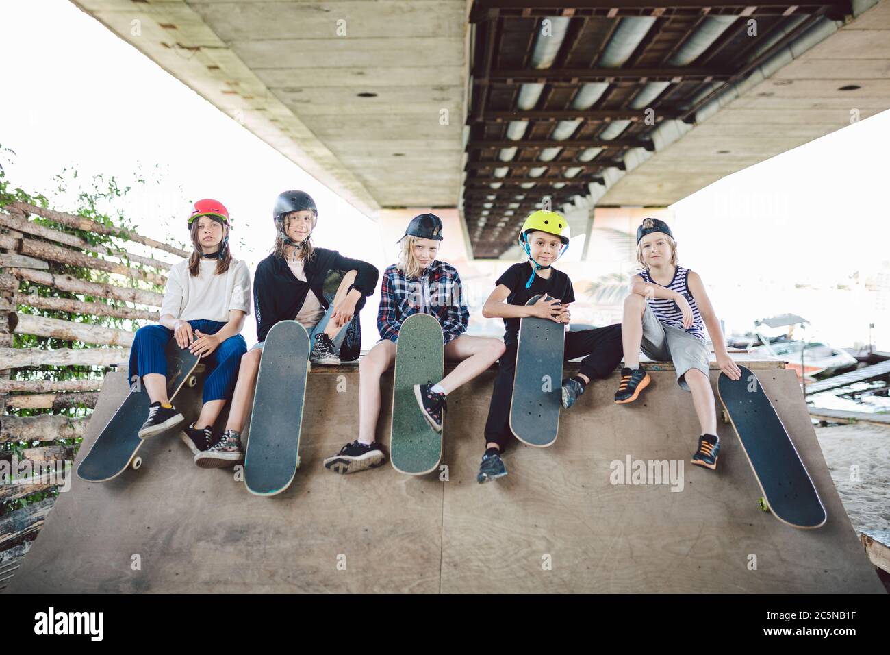 Group of friends children at skate ramp. Portrait of confident early ...