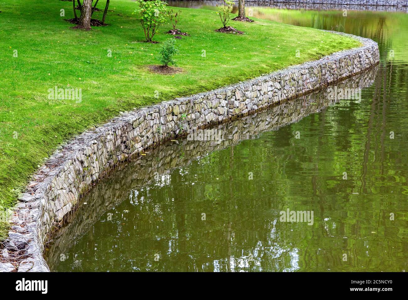 shore protection wall made of stone along the river, on the shore there ...