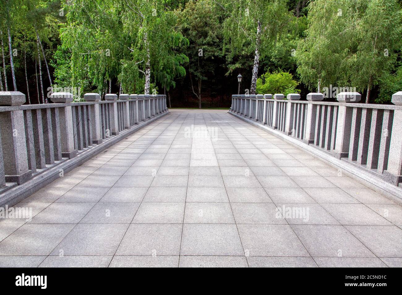 view of a bridge with stone tiles and granite railings with square ...