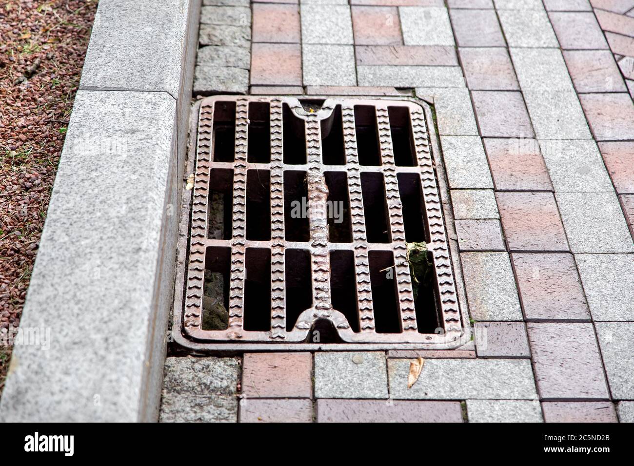 grille of the drainage system manhole on the pedestrian sidewalk made ...