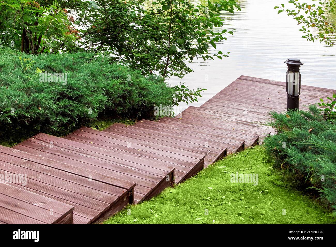 wooden steps down to the pier on the river, a slope with a landscape of ...