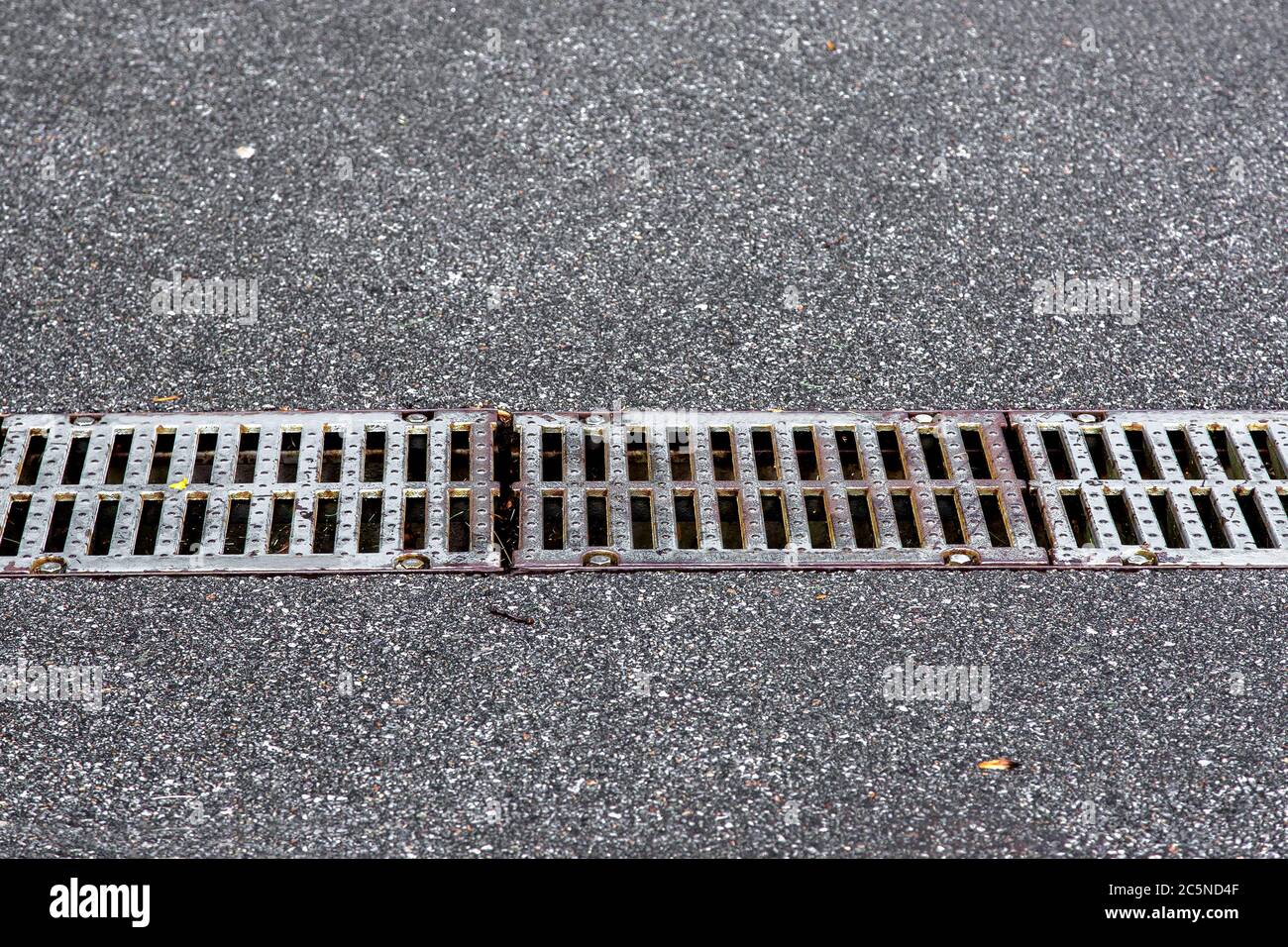 iron grid drainage system on an asphalt road, closeup Stock Photo - Alamy