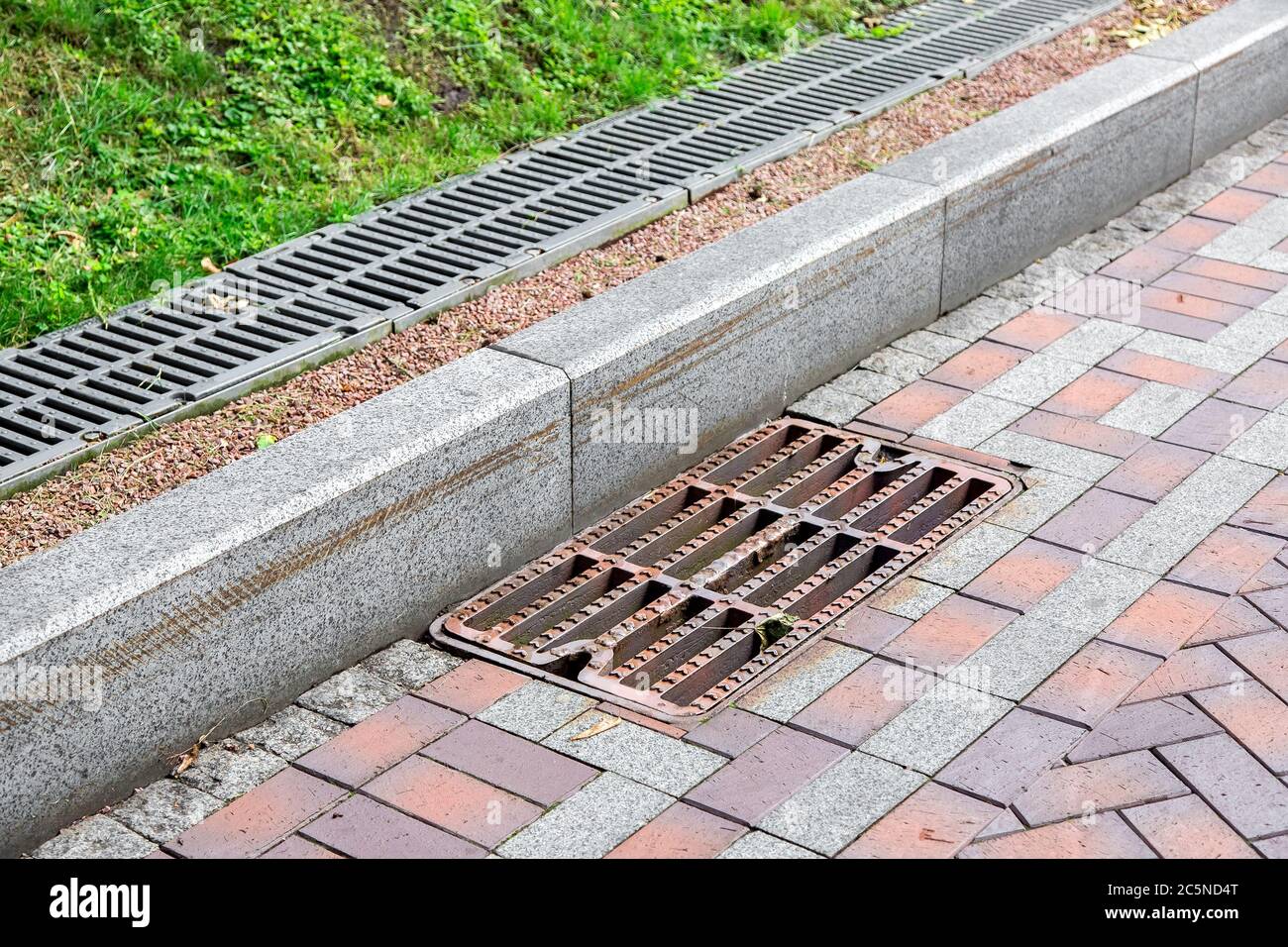 grille of the drainage system manhole on the pedestrian sidewalk made ...