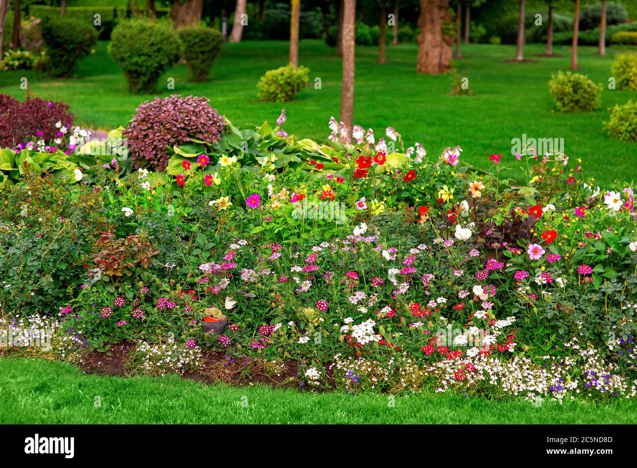 a landscape design colorfully flowerbed with lots flowers and bushes ...