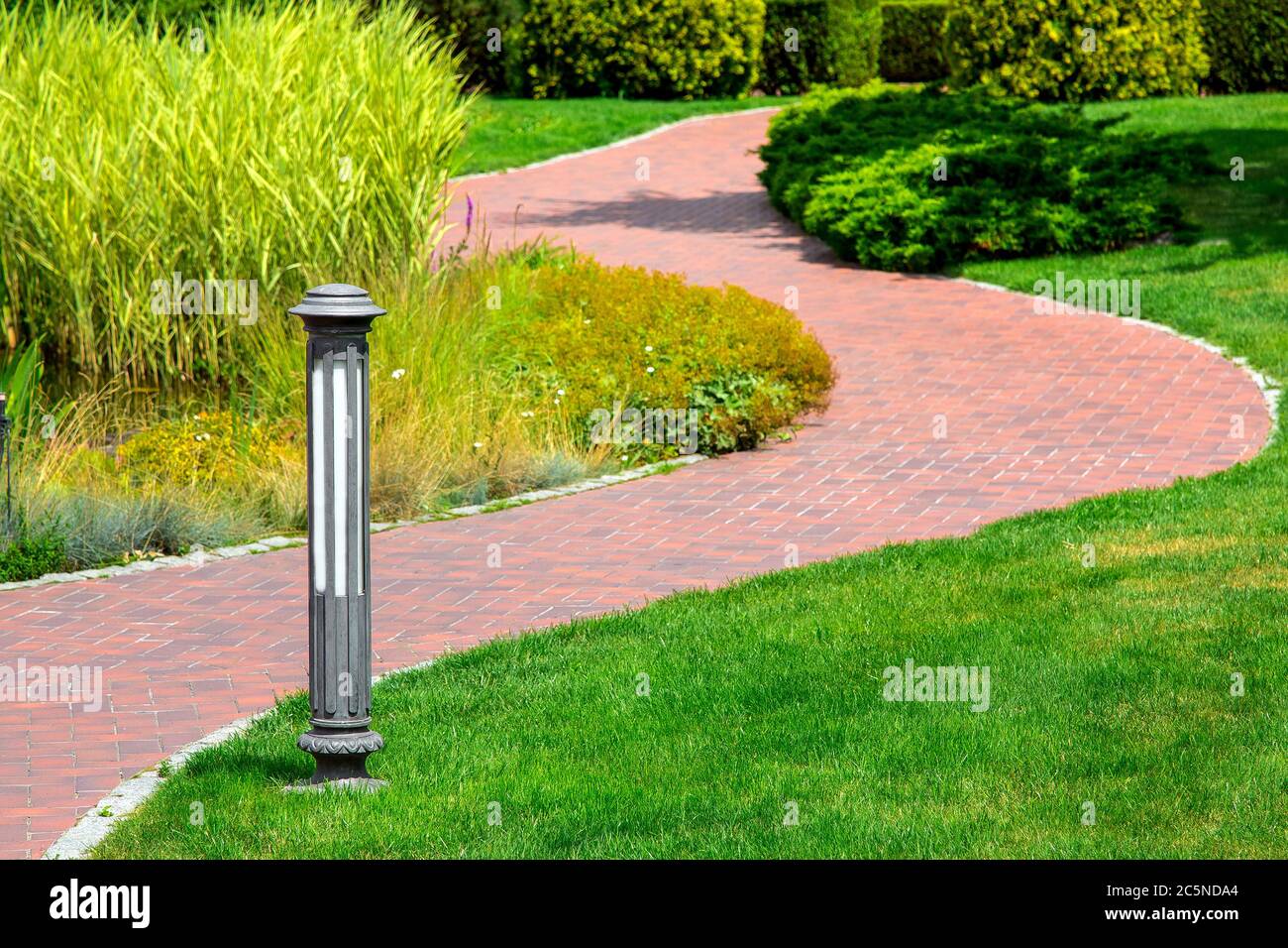 Lighting ground lamp street mounted on a green lawn in a park with ...